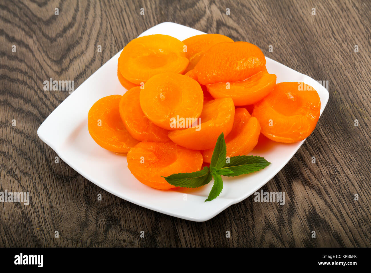 Canned apricots with mint leaves Stock Photo - Alamy