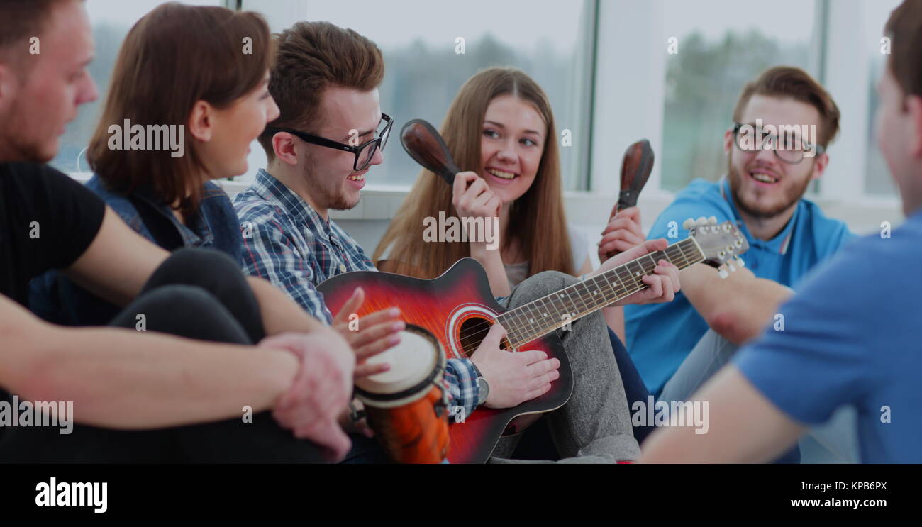 Happy young people having fun and playing different musical instruments ...