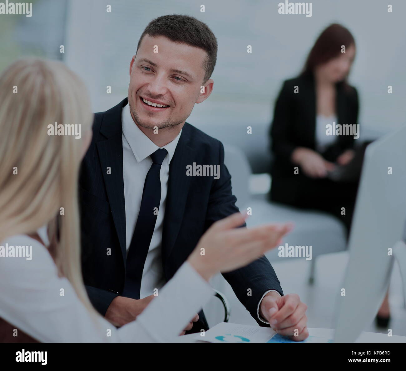 Young businesswoman showing something on computer as colleague looking ...