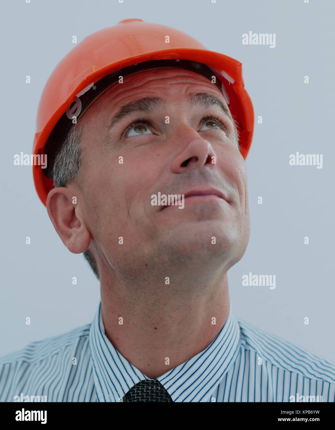 closeup of the face of the engineer looking up on white background. the ...