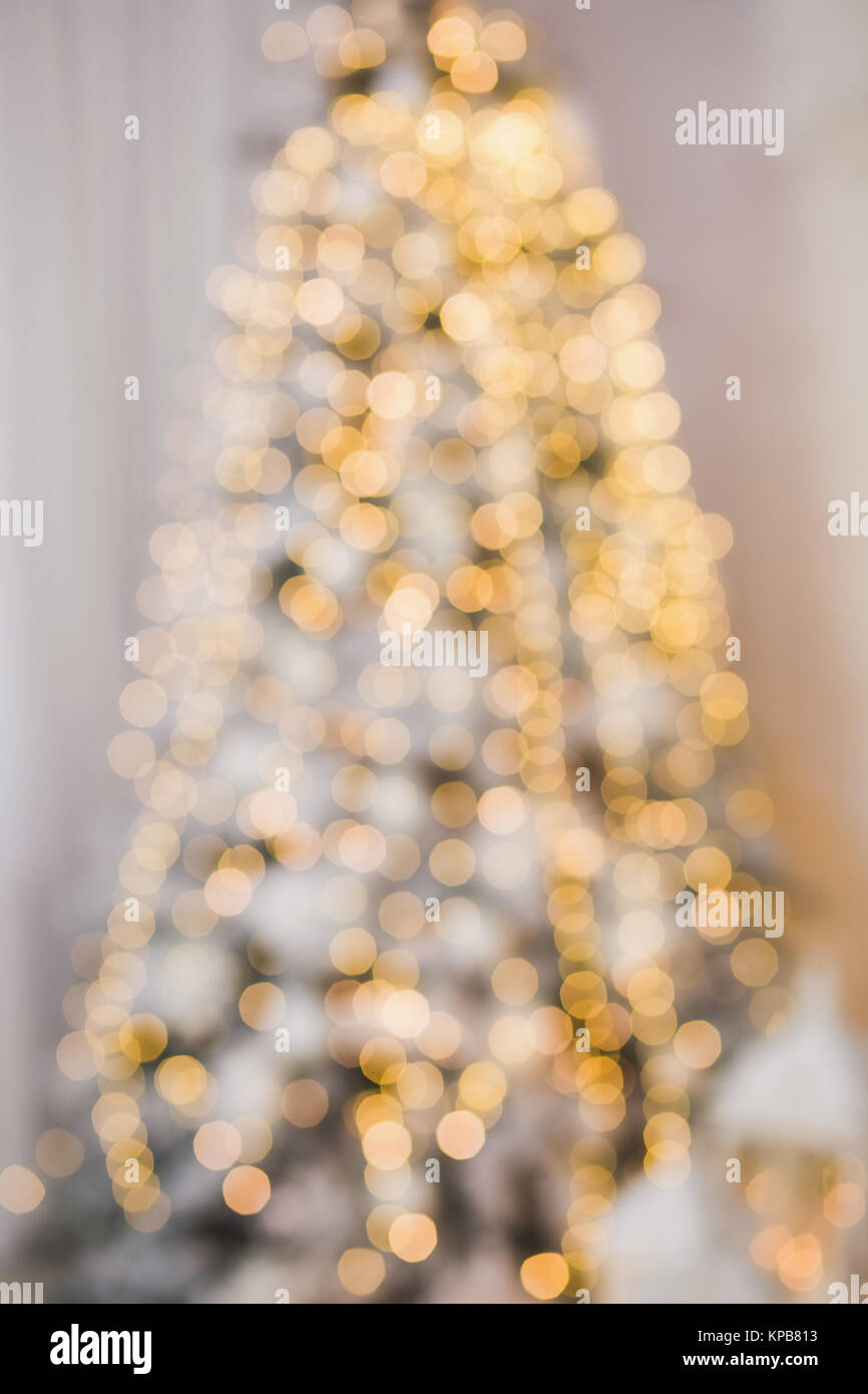 Blurred beautiful glowing Christmas tree in home interior. Vertical ...