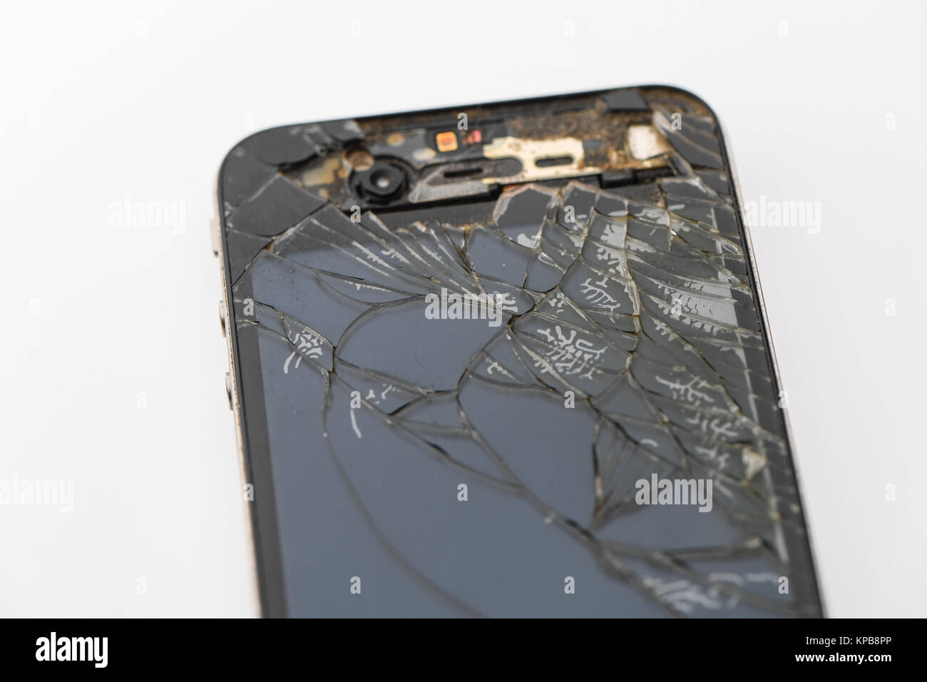 A badly cracked second generation iPhone on a white background Stock ...