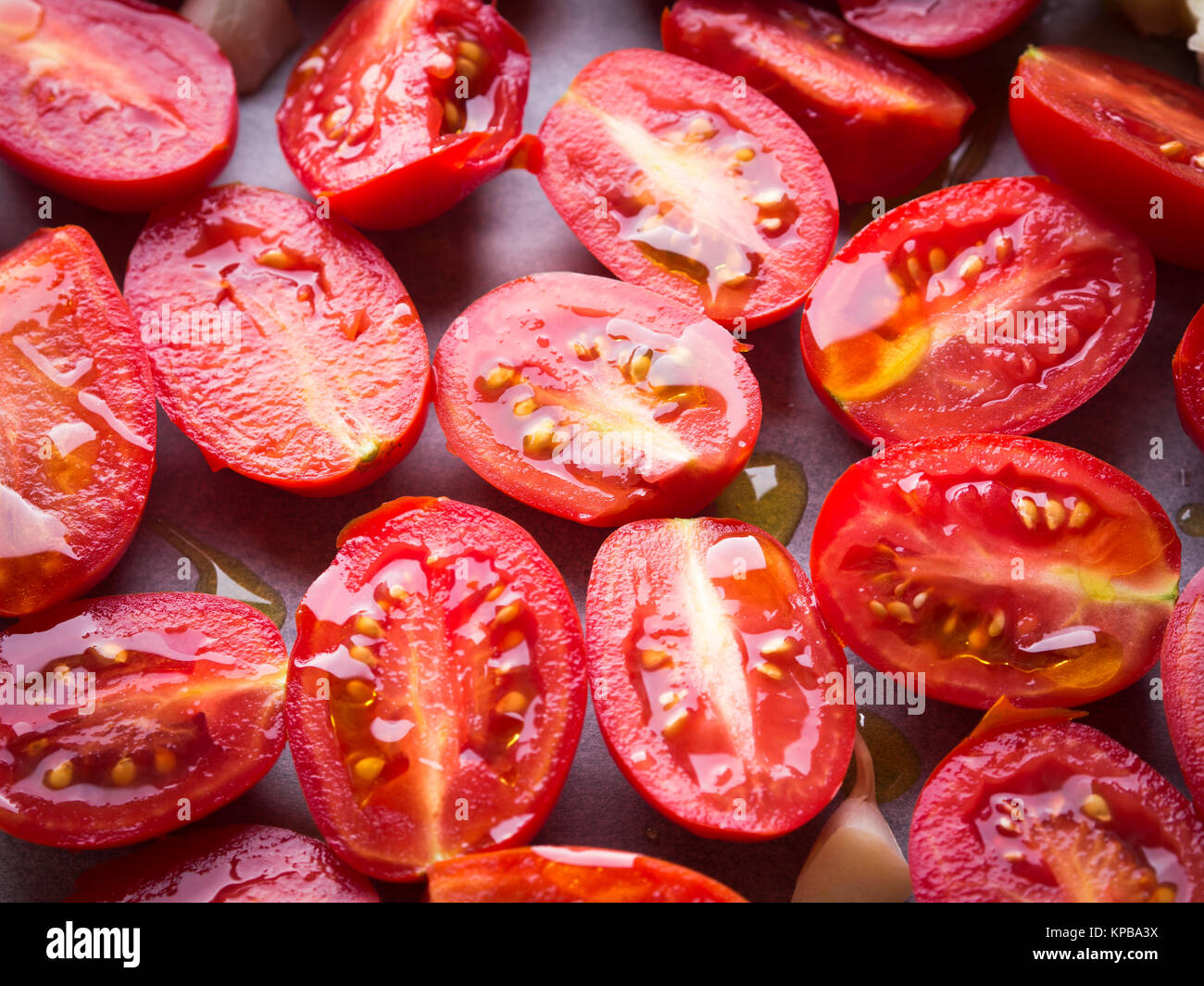 Red heirloom tomatoes ready to be baked with olive oil Stock Photo - Alamy