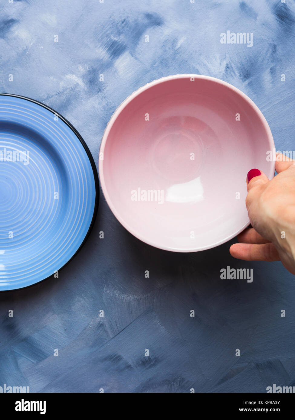 Pastel color plate and bowl with woman's hand holding it Stock Photo ...