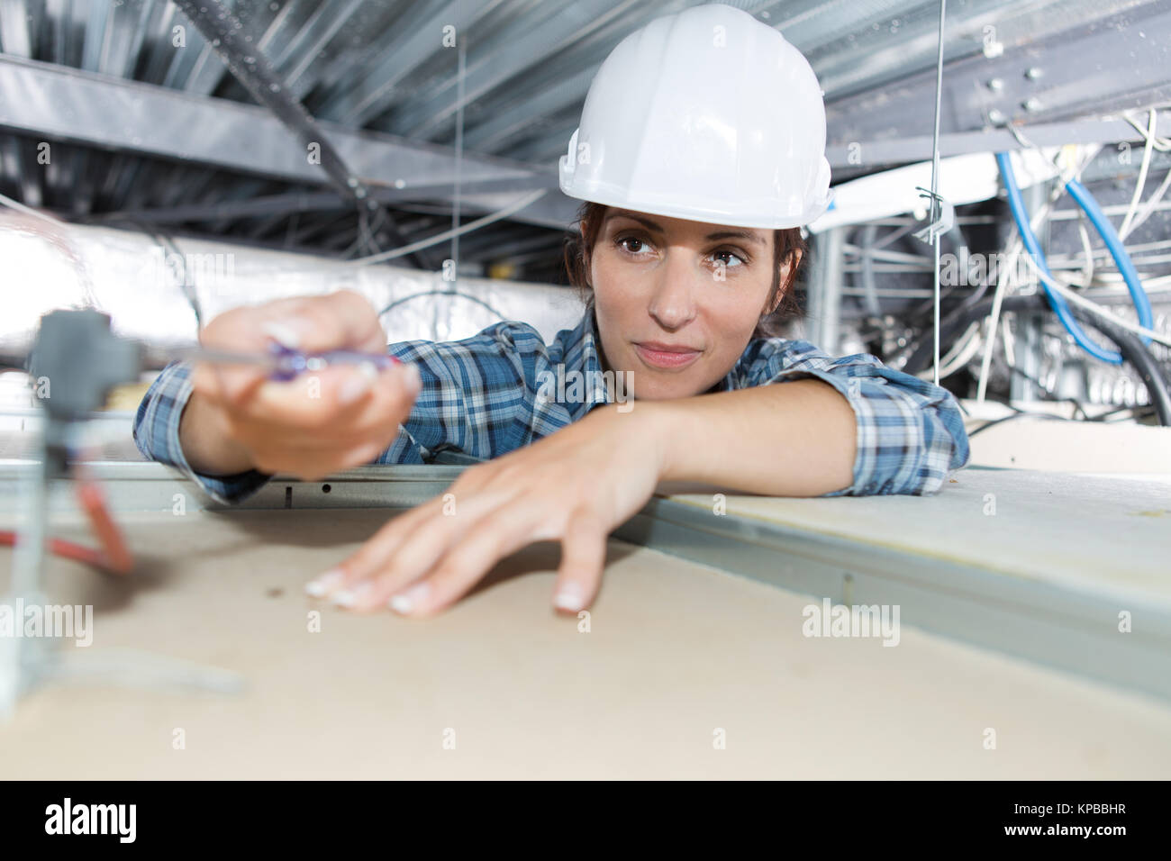 female electrician installing electric device in ceiling Stock Photo ...