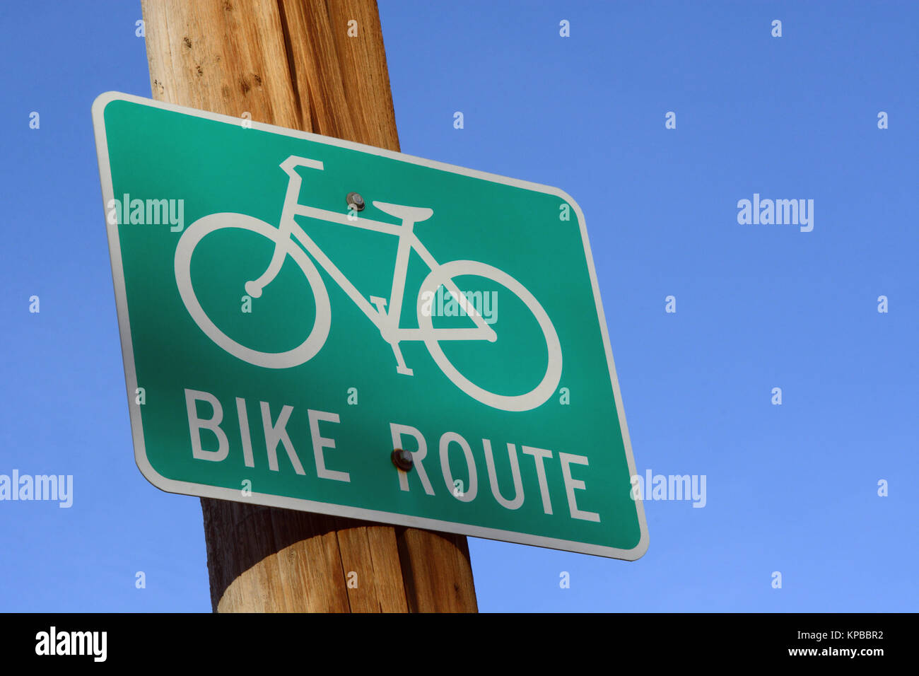 Bike route street sign on wooden pole against blue sky Stock Photo - Alamy