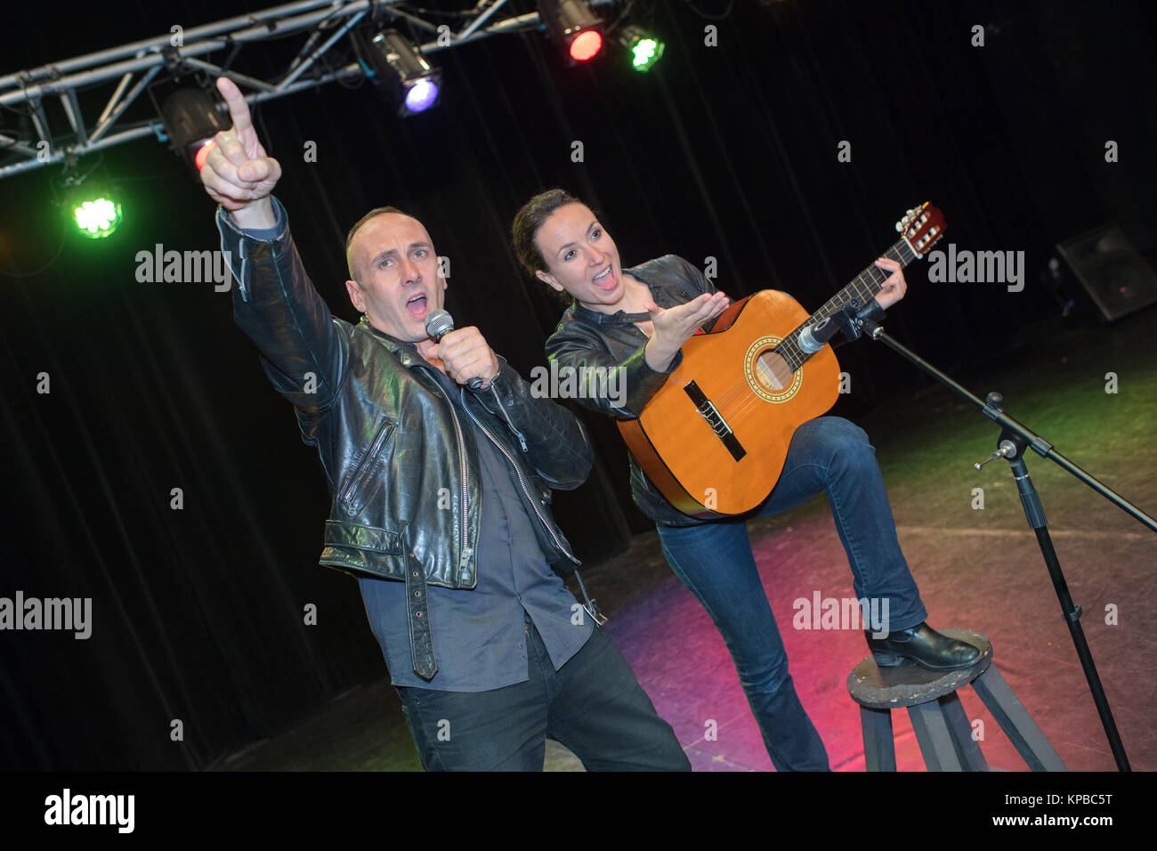 two people playing guitars and singing Stock Photo - Alamy