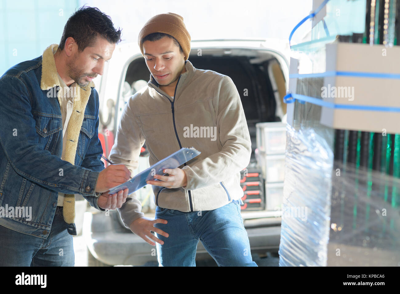 young male deliverer giving box to man Stock Photo - Alamy