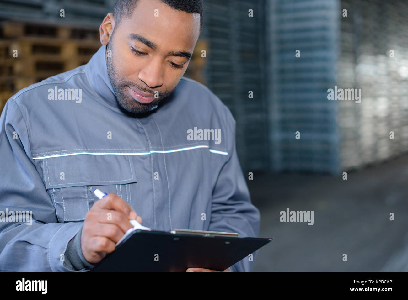 Male worker writing on clipboard Stock Photo - Alamy