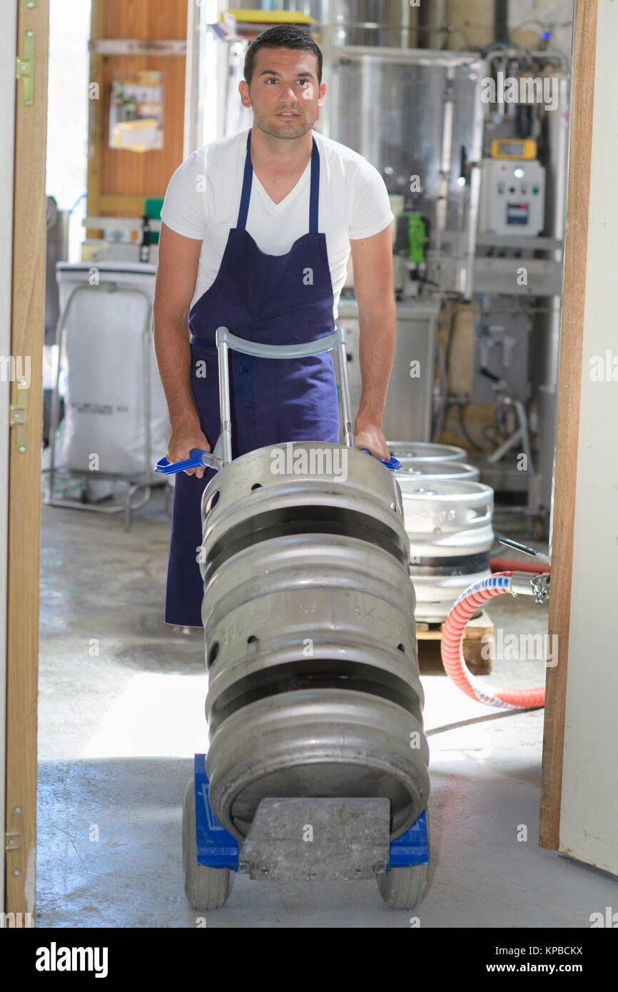 worker carrying barrel with beer at the brewery Stock Photo - Alamy