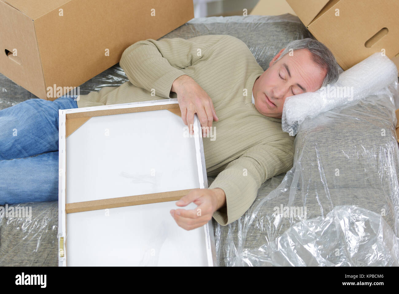 man sleeping in between boxes Stock Photo - Alamy