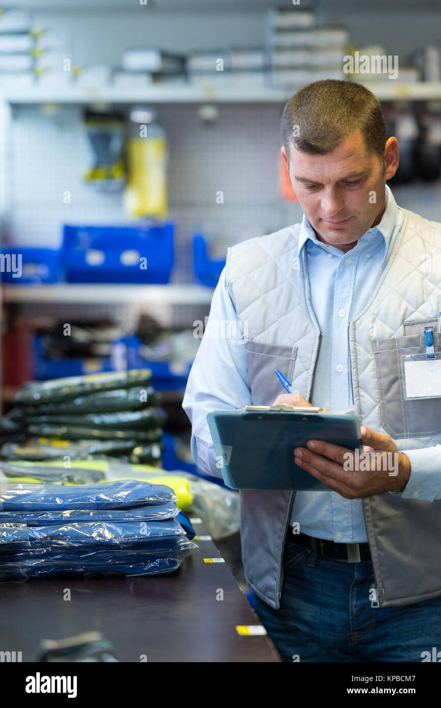 man with clipboard checking orders at logistics company Stock Photo - Alamy