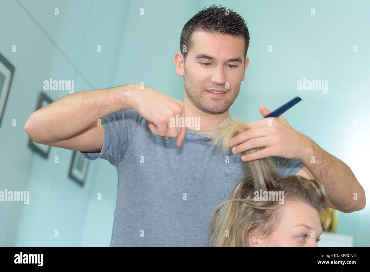 happy young male hairdresser cutting customers hair at salon Stock ...