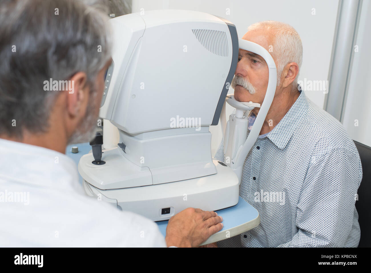 Patient resting chin on ophthalmologist's equipment Stock Photo - Alamy