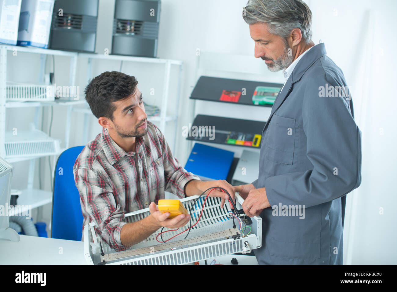 teacher helping student training to be electrician Stock Photo - Alamy