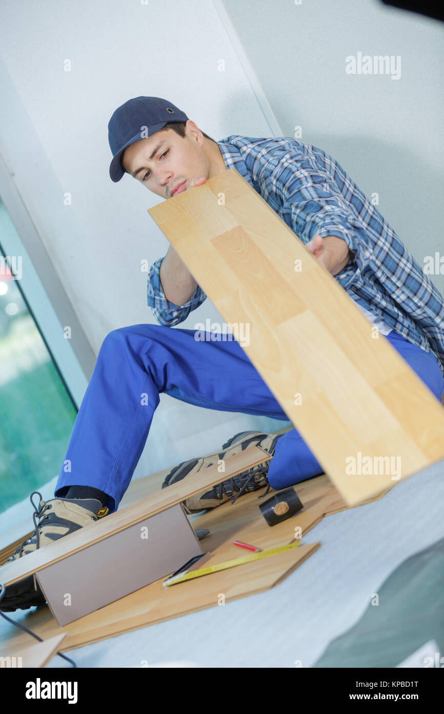 young technician installing floor at construction site Stock Photo - Alamy