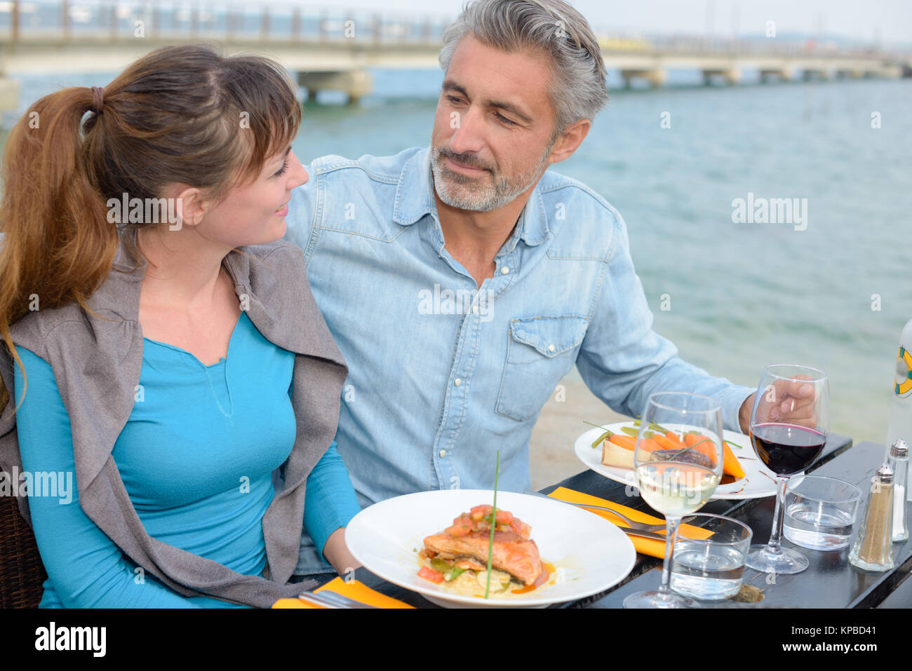 Man and lady eating at waterside restaurant Stock Photo - Alamy