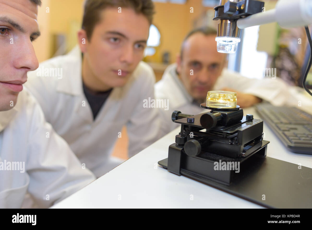Students performing experiment with microscope Stock Photo - Alamy
