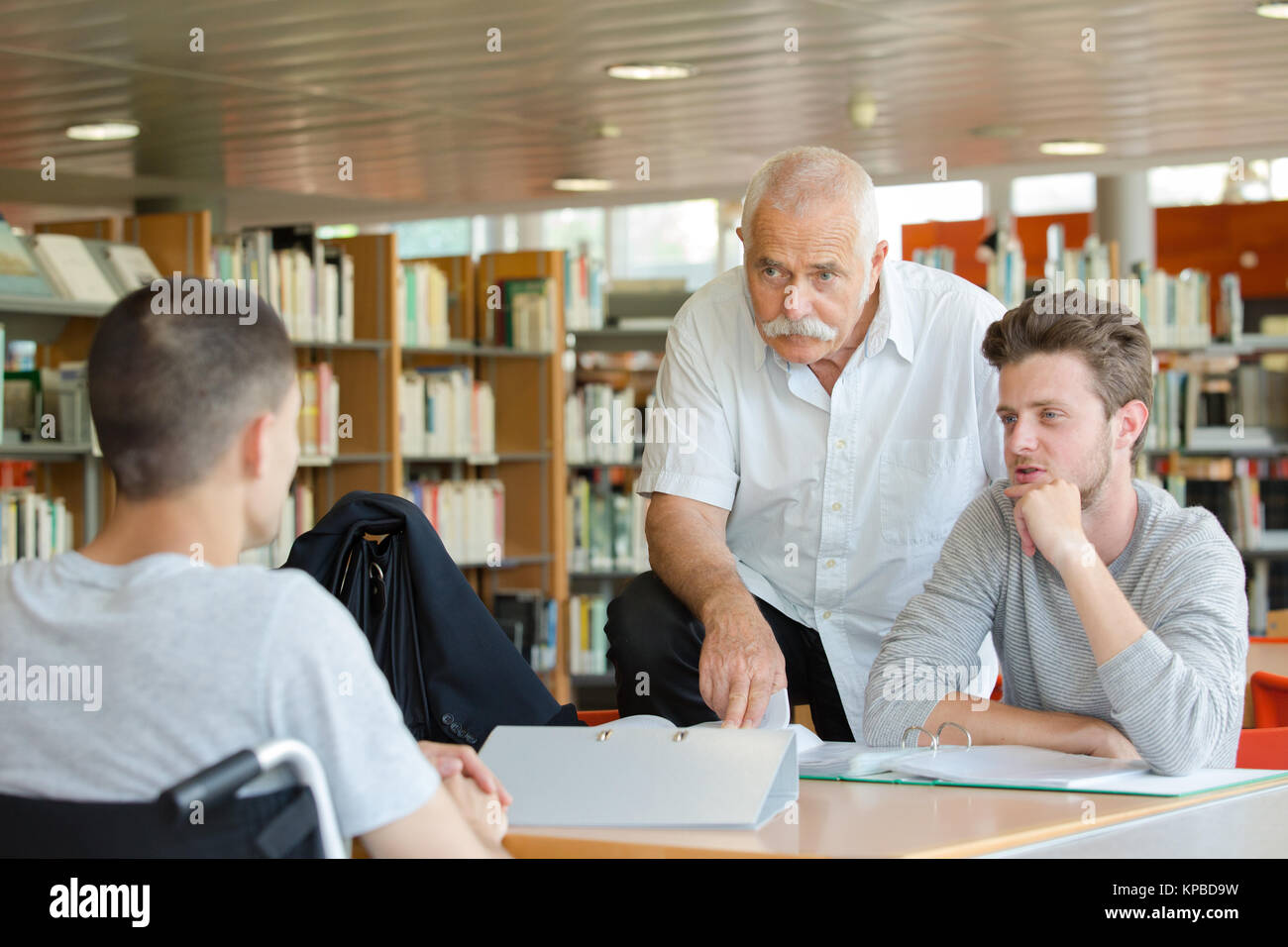 experienced teacher giving extra lesson in library Stock Photo - Alamy