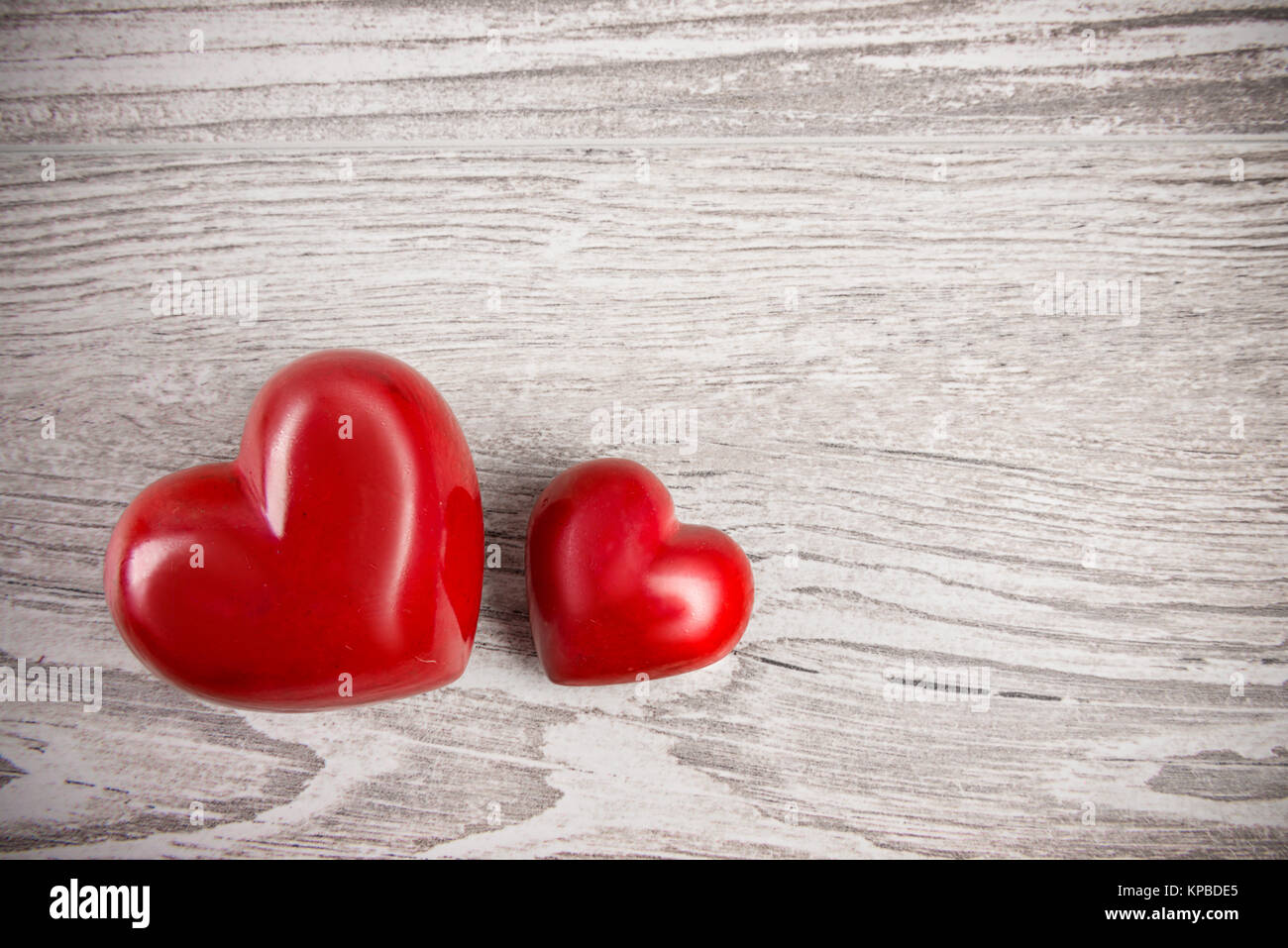 Two red stone hearts on neutral background, space for your greeting ...