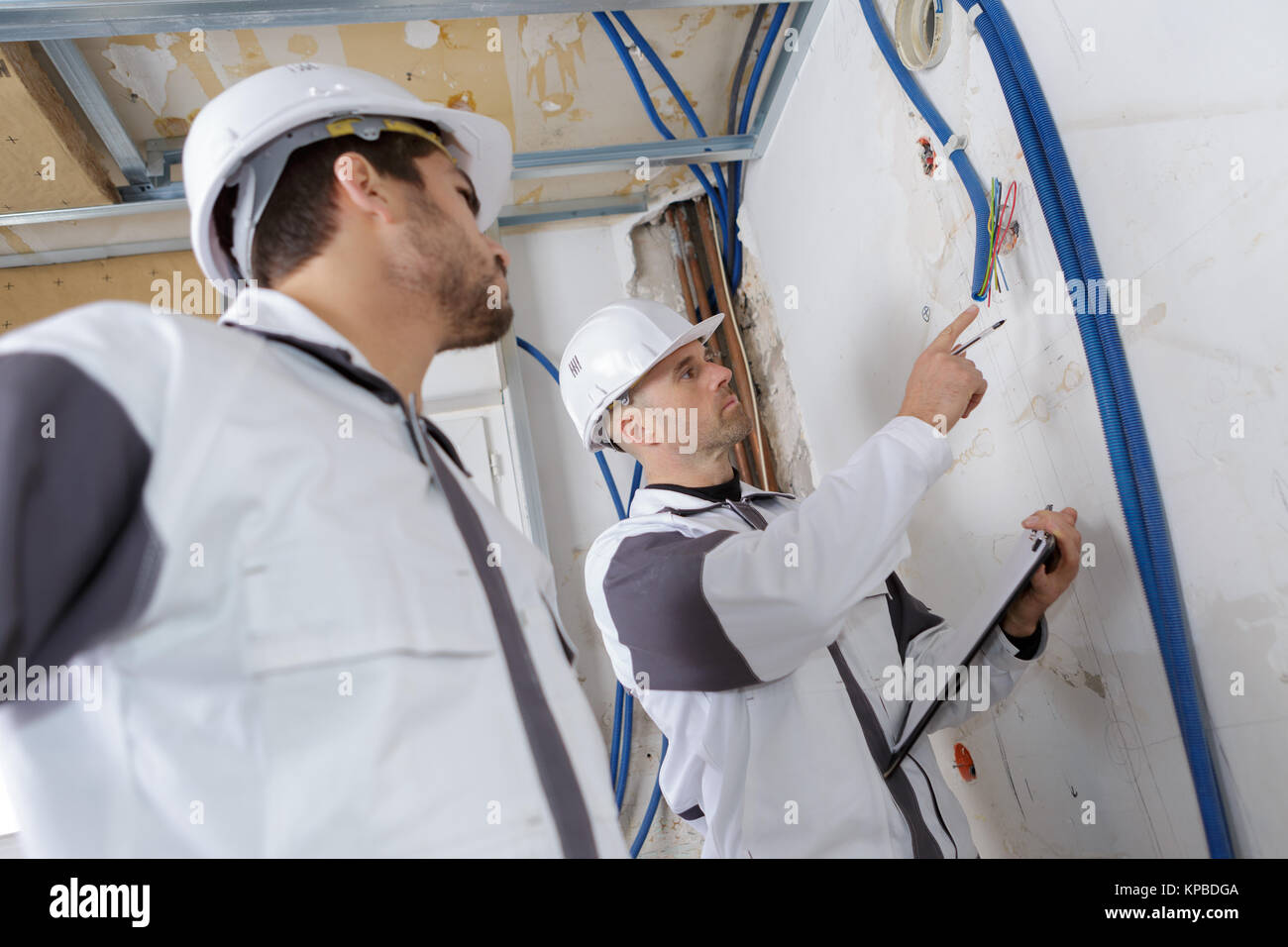 male builders checking hose pipe insulation Stock Photo - Alamy