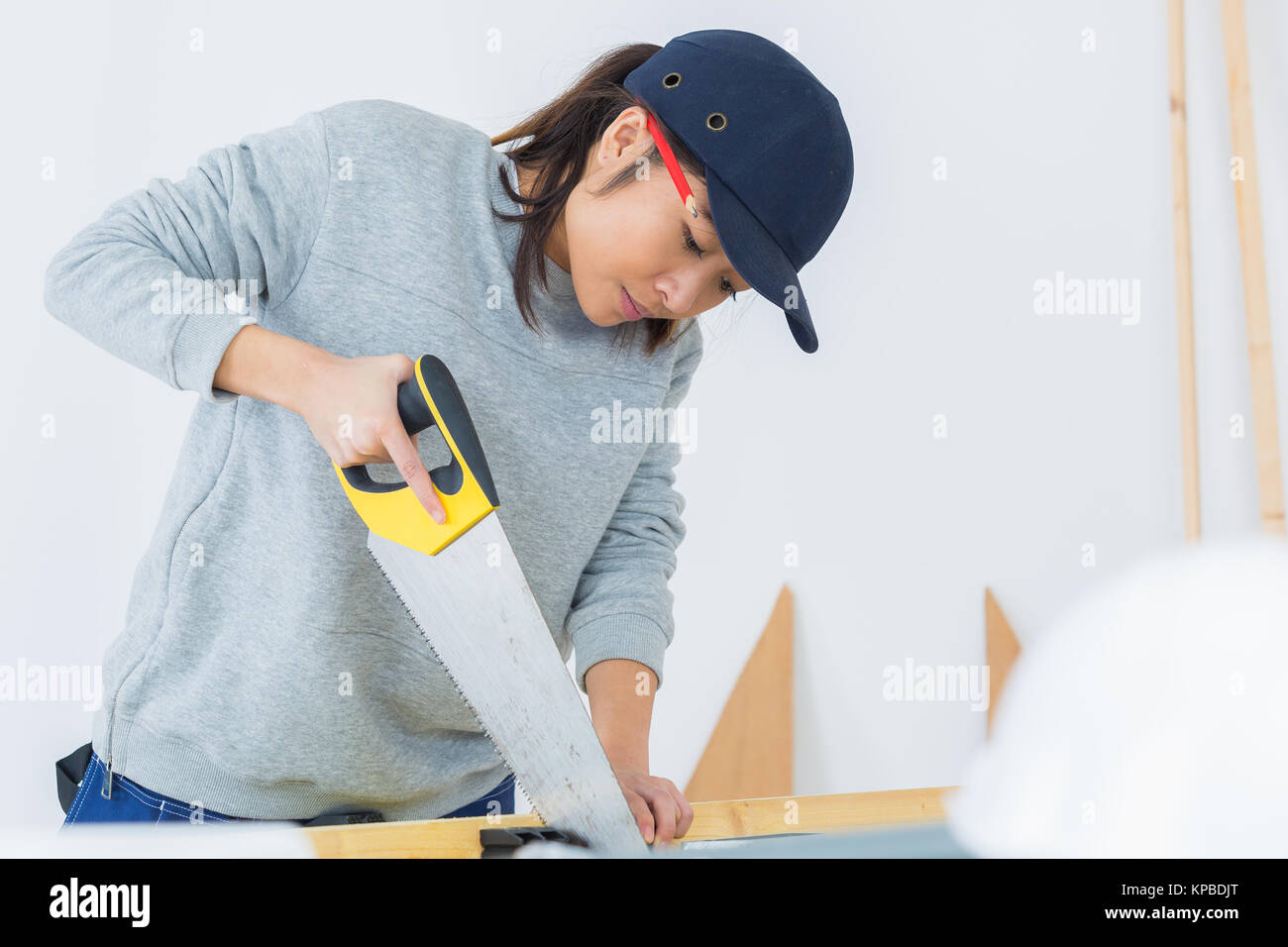 concentrated young female carpenter cutting wood Stock Photo - Alamy