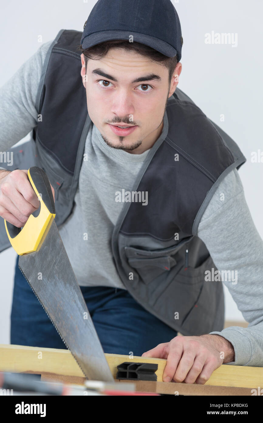 Portrait of man using hand saw Stock Photo - Alamy