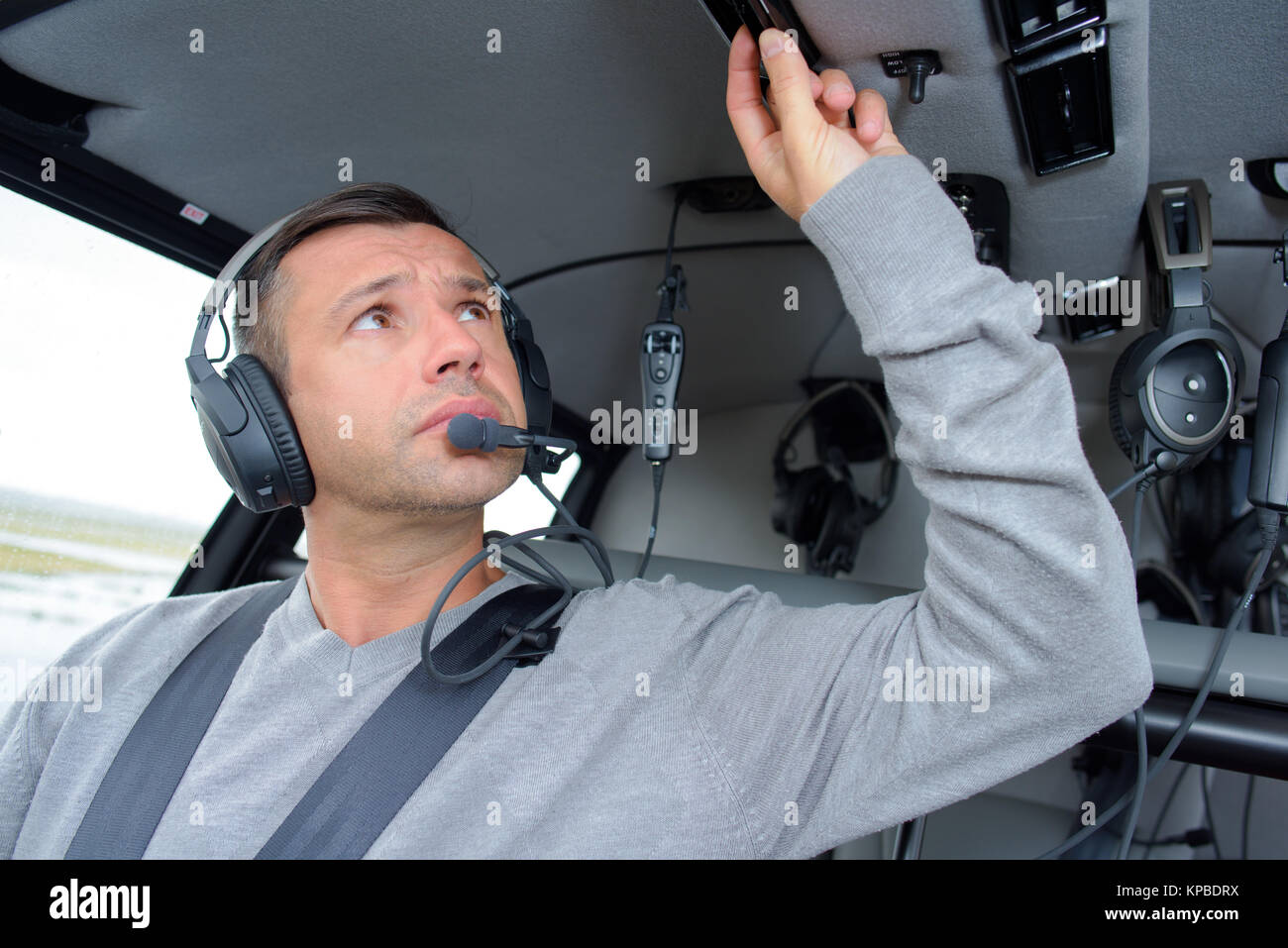 Pilot adjusting overhead controls Stock Photo - Alamy