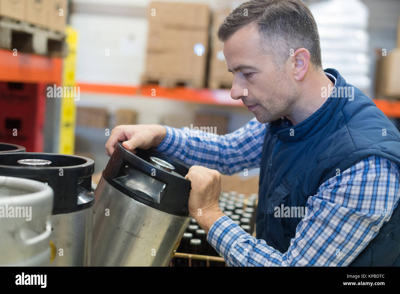 man sorting metallic beer barrels Stock Photo - Alamy