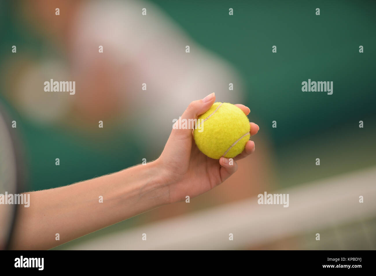 woman giving tennis ball in hand to you for play Stock Photo - Alamy