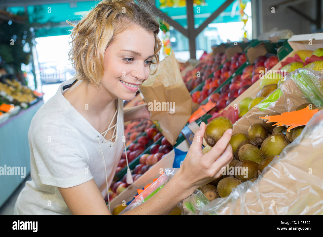 female customer with little choosing fruits in food shop Stock Photo ...