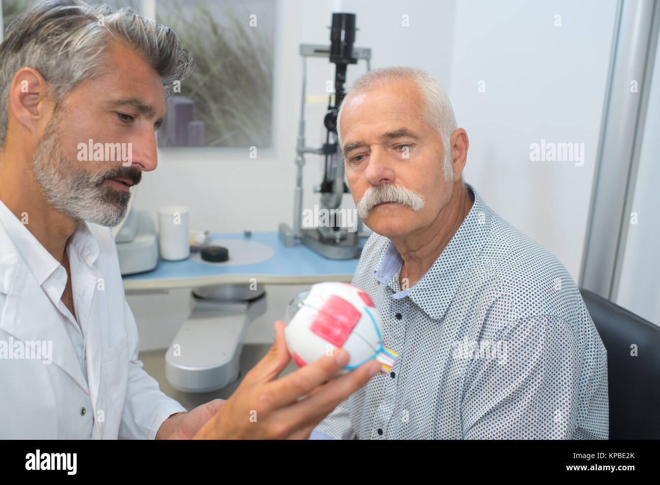 doctor showing senior patient the eye models anatomy Stock Photo - Alamy