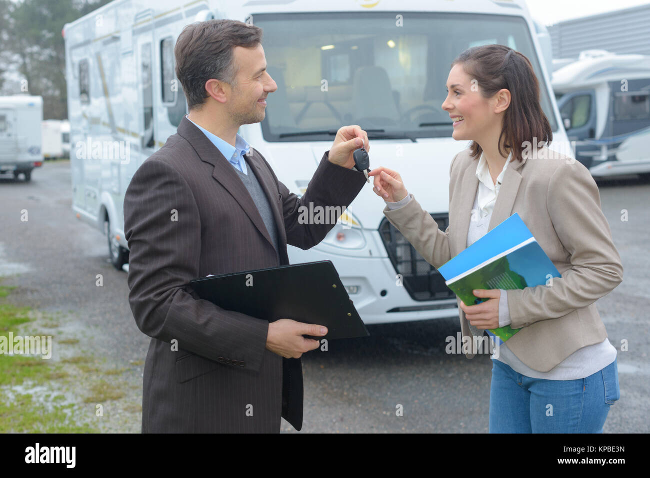 Salesman handing motorhome keys to woman Stock Photo - Alamy