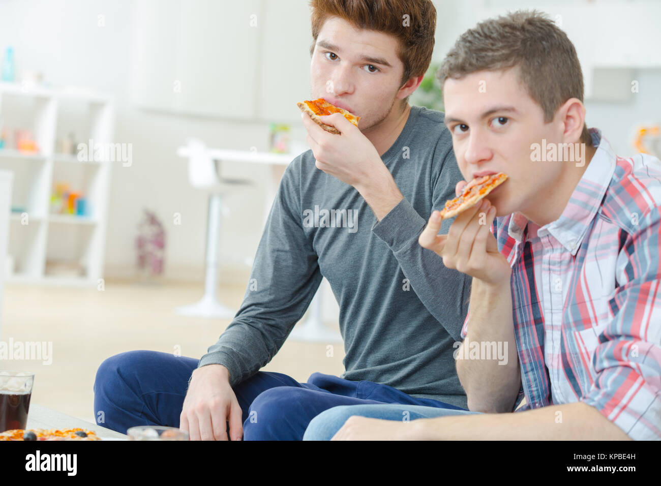 Two mates sharing a pizza Stock Photo - Alamy
