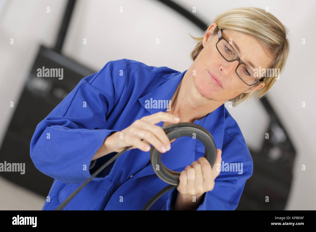 female mechanic picking up spare part at the garage Stock Photo - Alamy