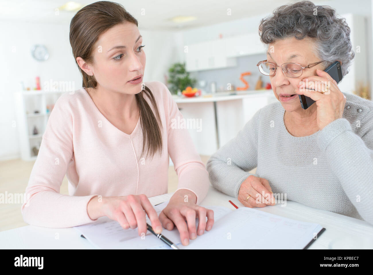 granddaughter teaching grandma how to use smartphone Stock Photo - Alamy