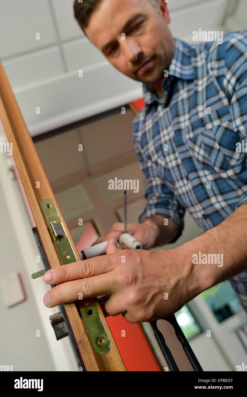 Man fitting a new door lock Stock Photo - Alamy