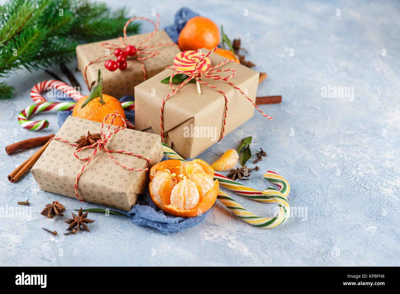 Fresh mandarins with leaves, candy canes, gift boxes in kraft paper and ...