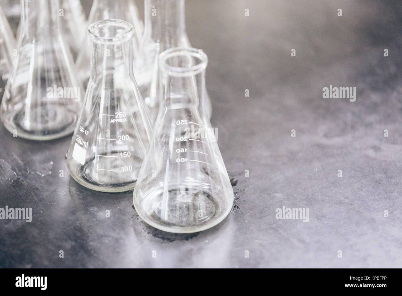 detail shot of beakers and equipment on table in factory laboratory ...