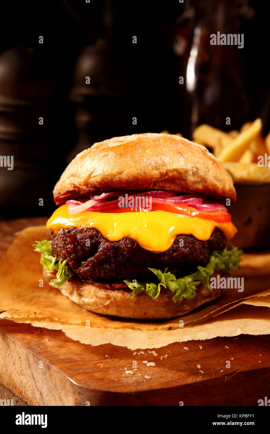 Traditional American cheeseburger on a crusty bun with fresh salad ...