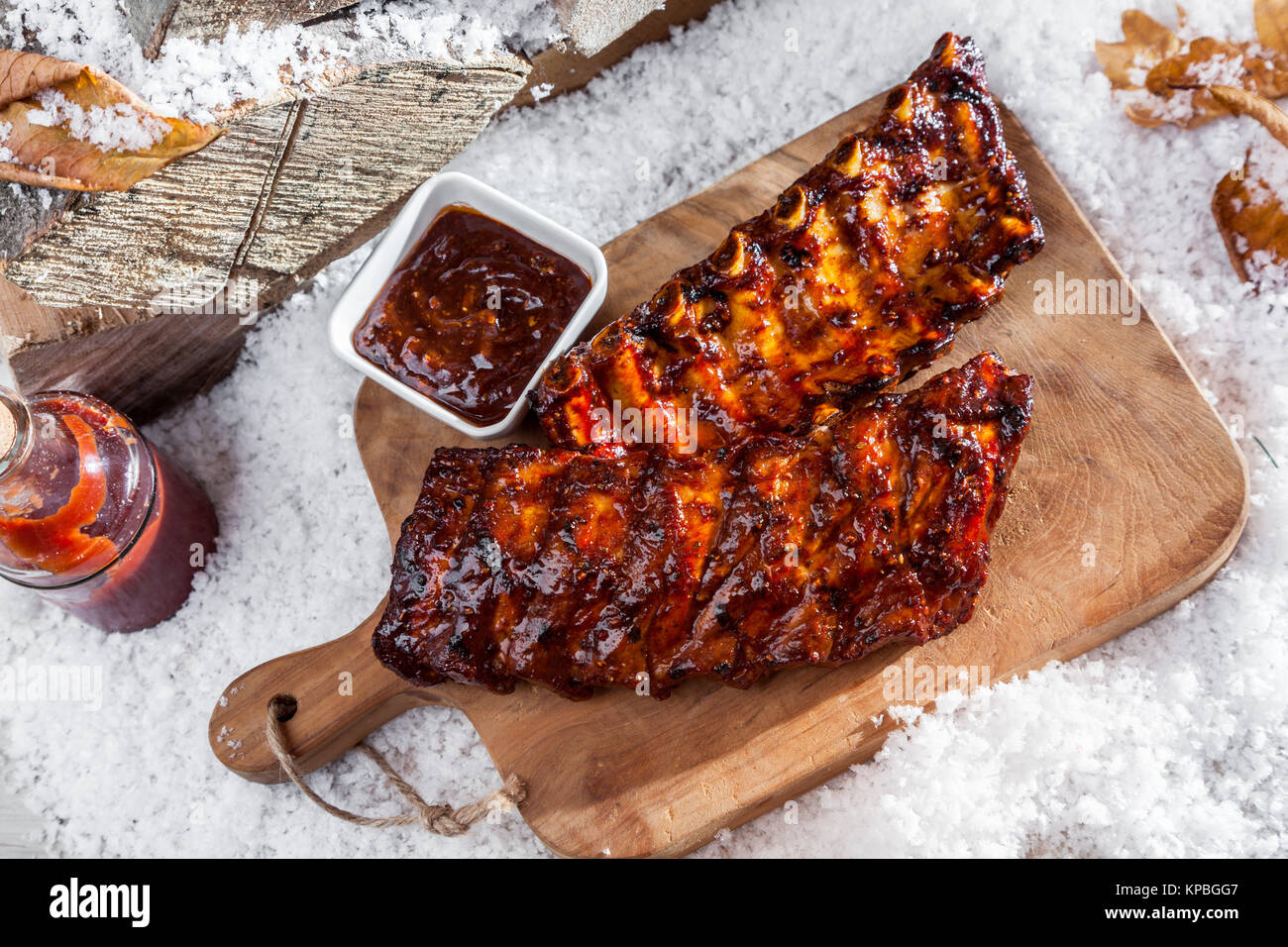 Two portions of grilled spicy spare ribs cooked on a winter barbecue ...