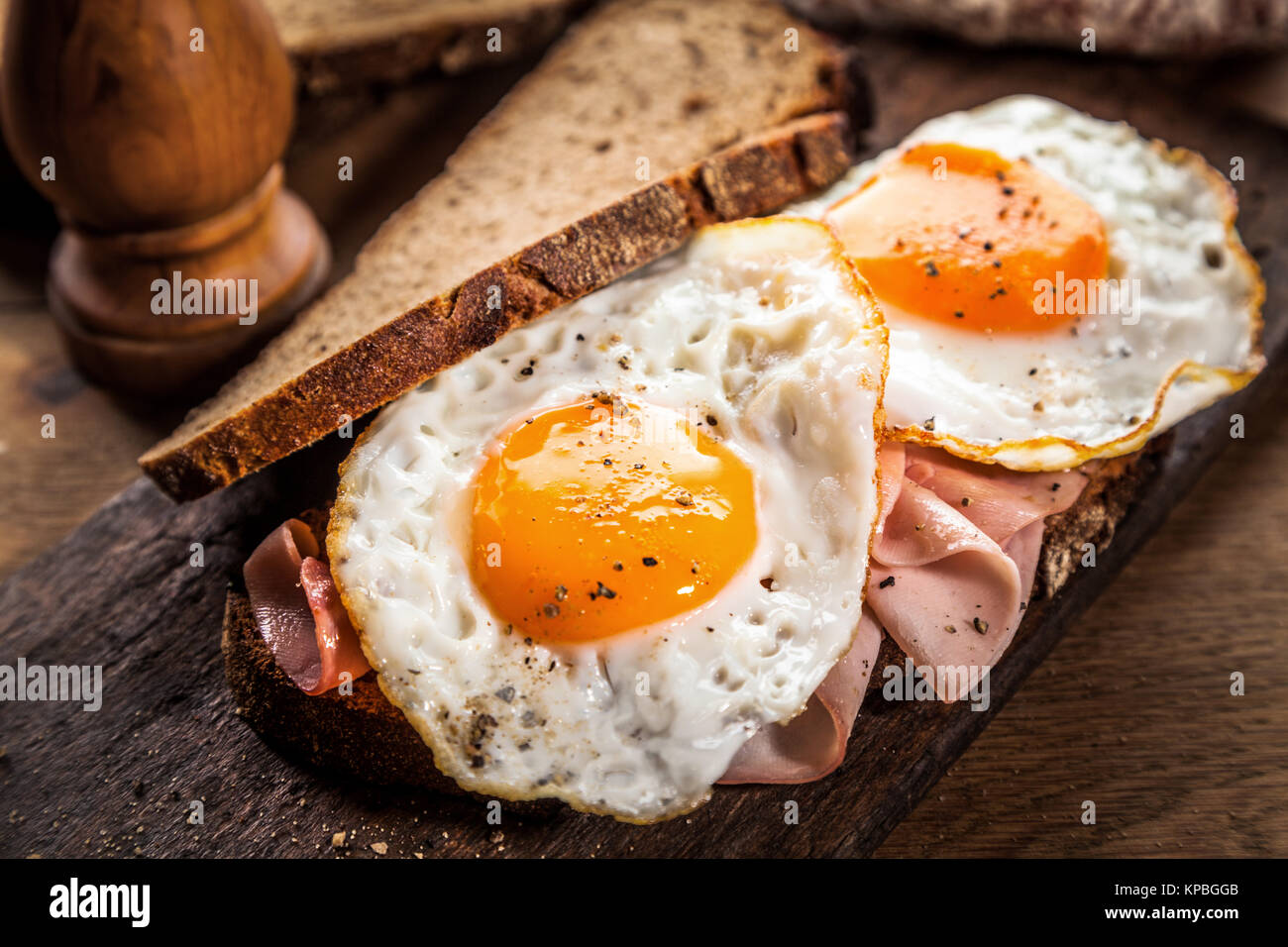Fried eggs and ham served on healthy wholegrain bread for breakfast in ...