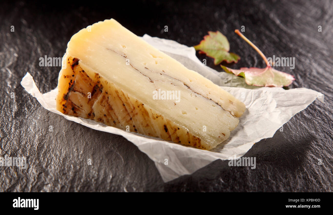 Close Up of Wedge of Semi-Soft Cheese with Dark Veins on Piece of Wax ...