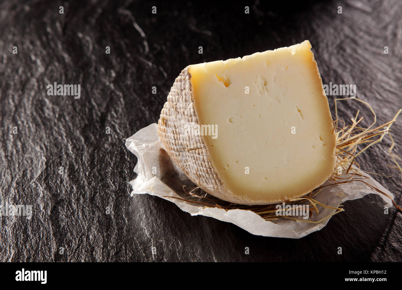 Wedge of Semi-Soft Cheese Cut from Round Wheel Served on Piece of Wax ...