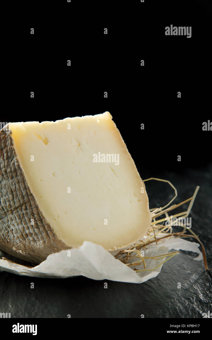 Rounds of Semi Ripened Cheese, One Cut and One Whole, on Piece of Wax ...
