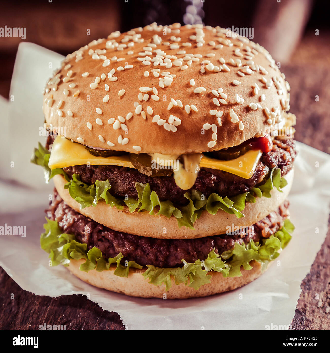 Delicious double cheeseburger with a slab of melted cheese over two ...