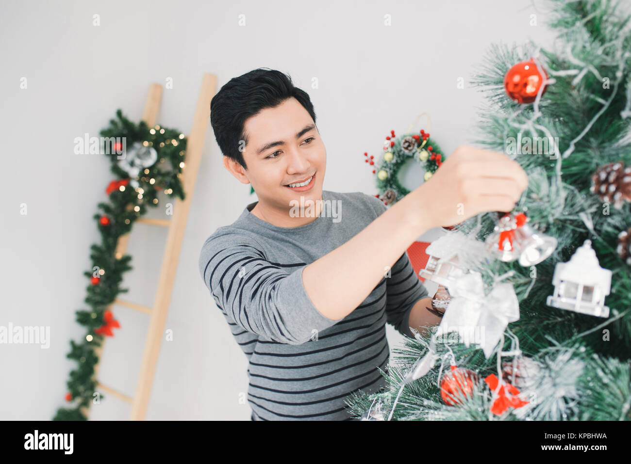 Christmas. Asian Handsome Man standing new Xmas tree at home ...