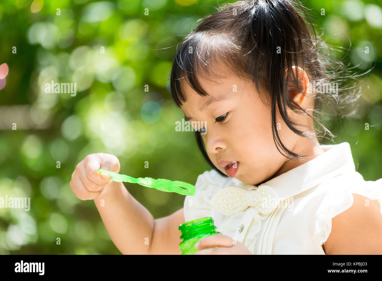 Cute girl play with bubble blower Stock Photo - Alamy