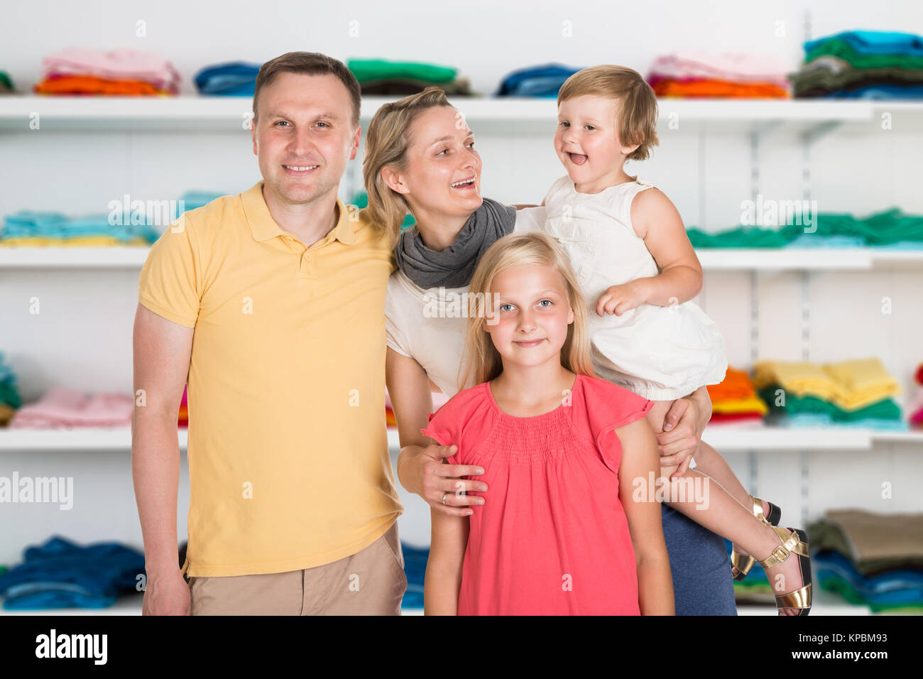 Happy Family Standing At Clothing Store Stock Photo - Alamy