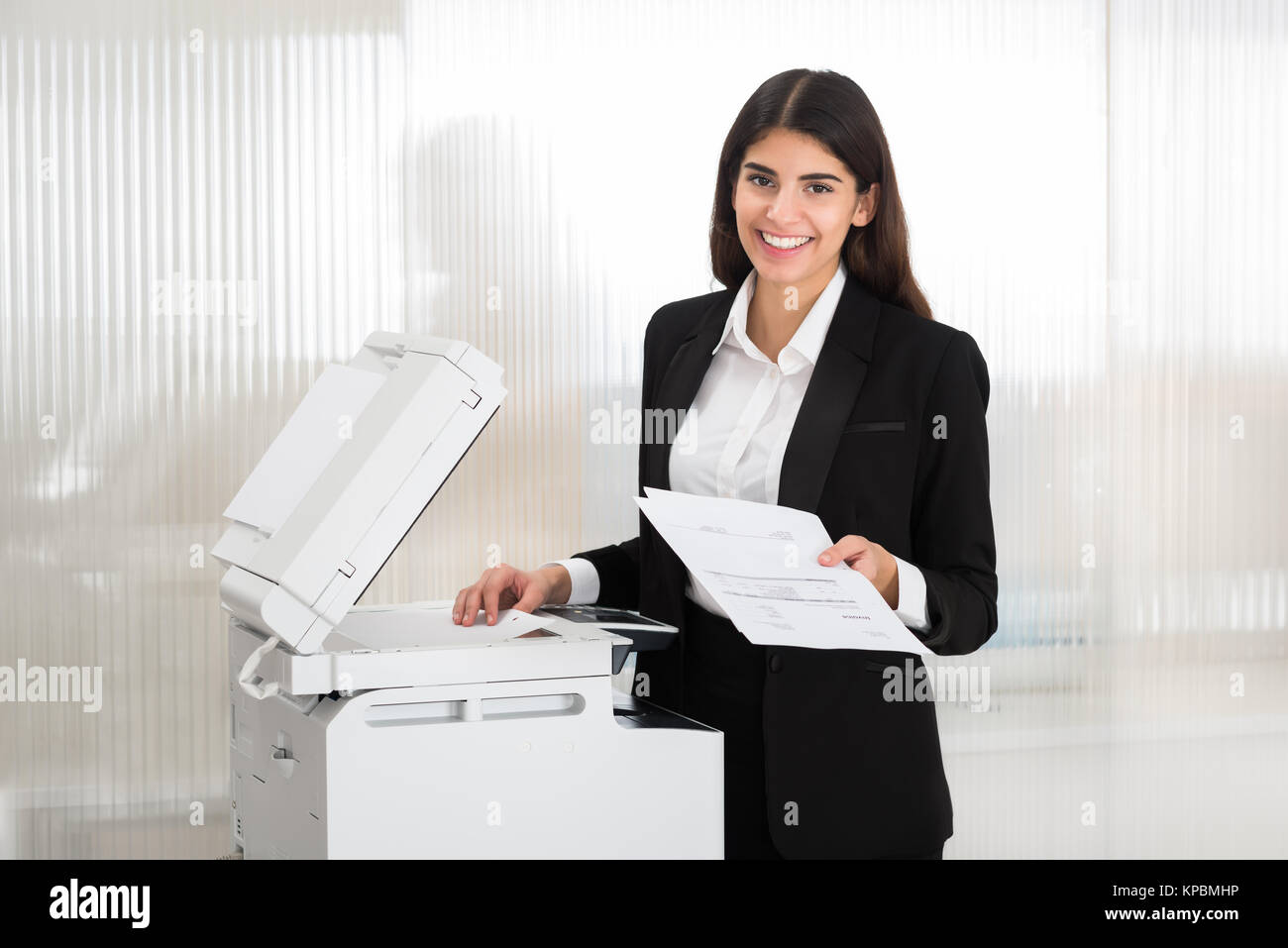 Businesswoman Using Photocopy Machine In Office Stock Photo - Alamy